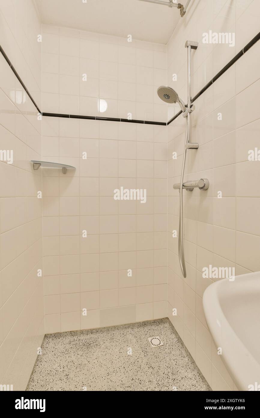 A modern, minimalist bathroom featuring a white tile design with a ...