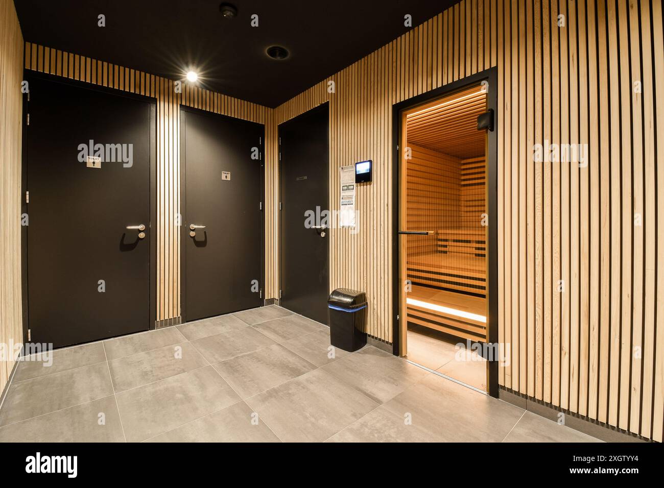 Contemporary fitness center restroom featuring sleek wooden slats ...