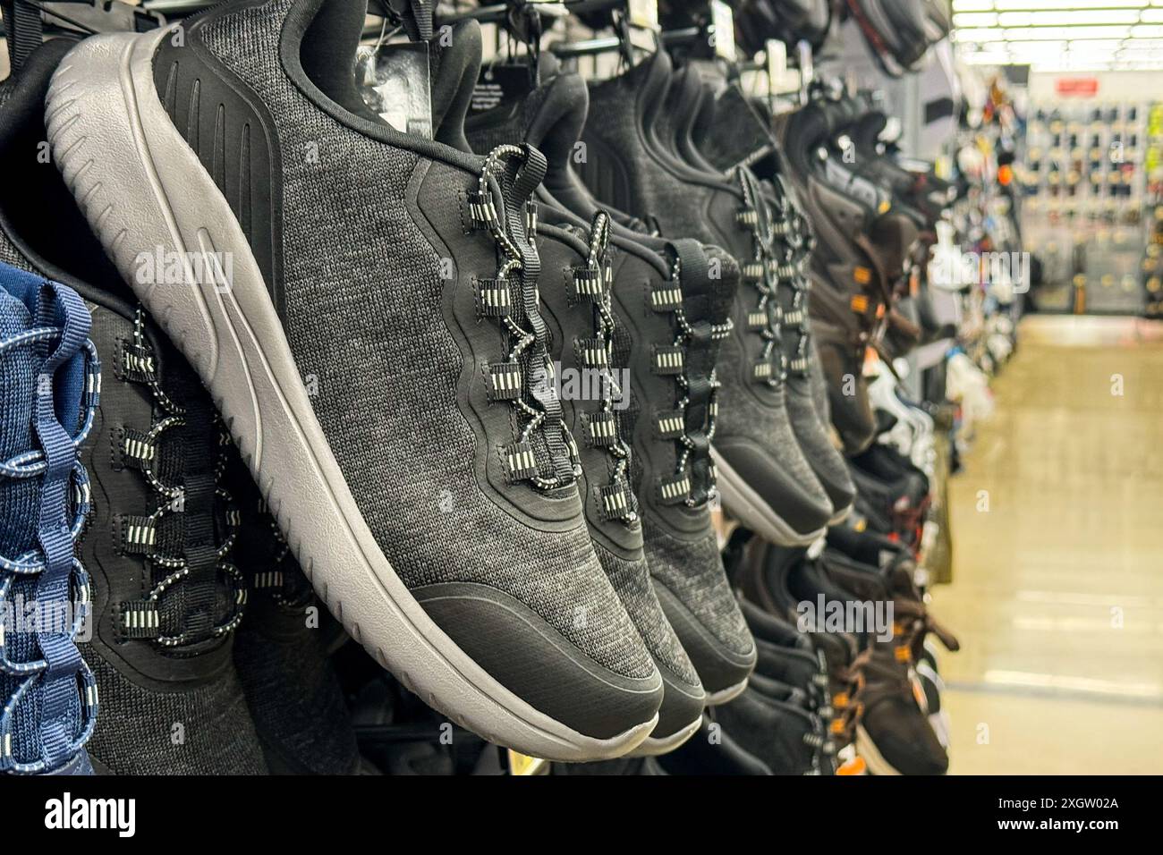 a row of gray athletic shoes on display in a store Stock Photo - Alamy