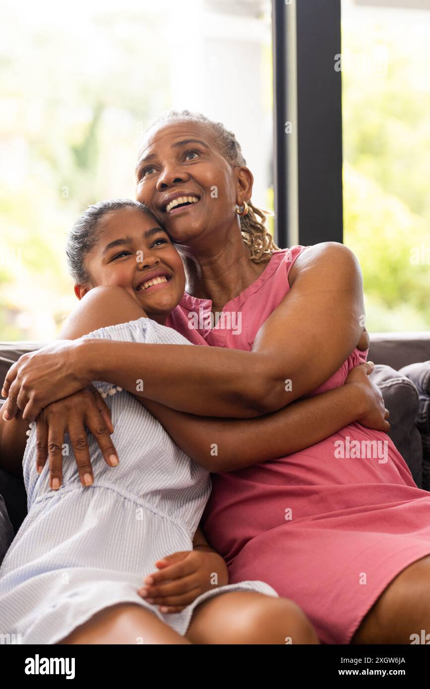 Senior African American grandmother embraces a teenage biracial ...