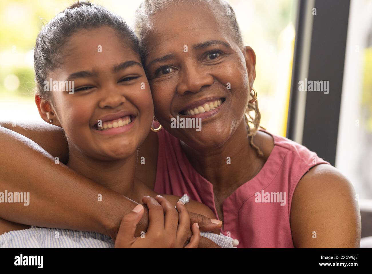 Senior African American grandmother embraces a teenage biracial ...