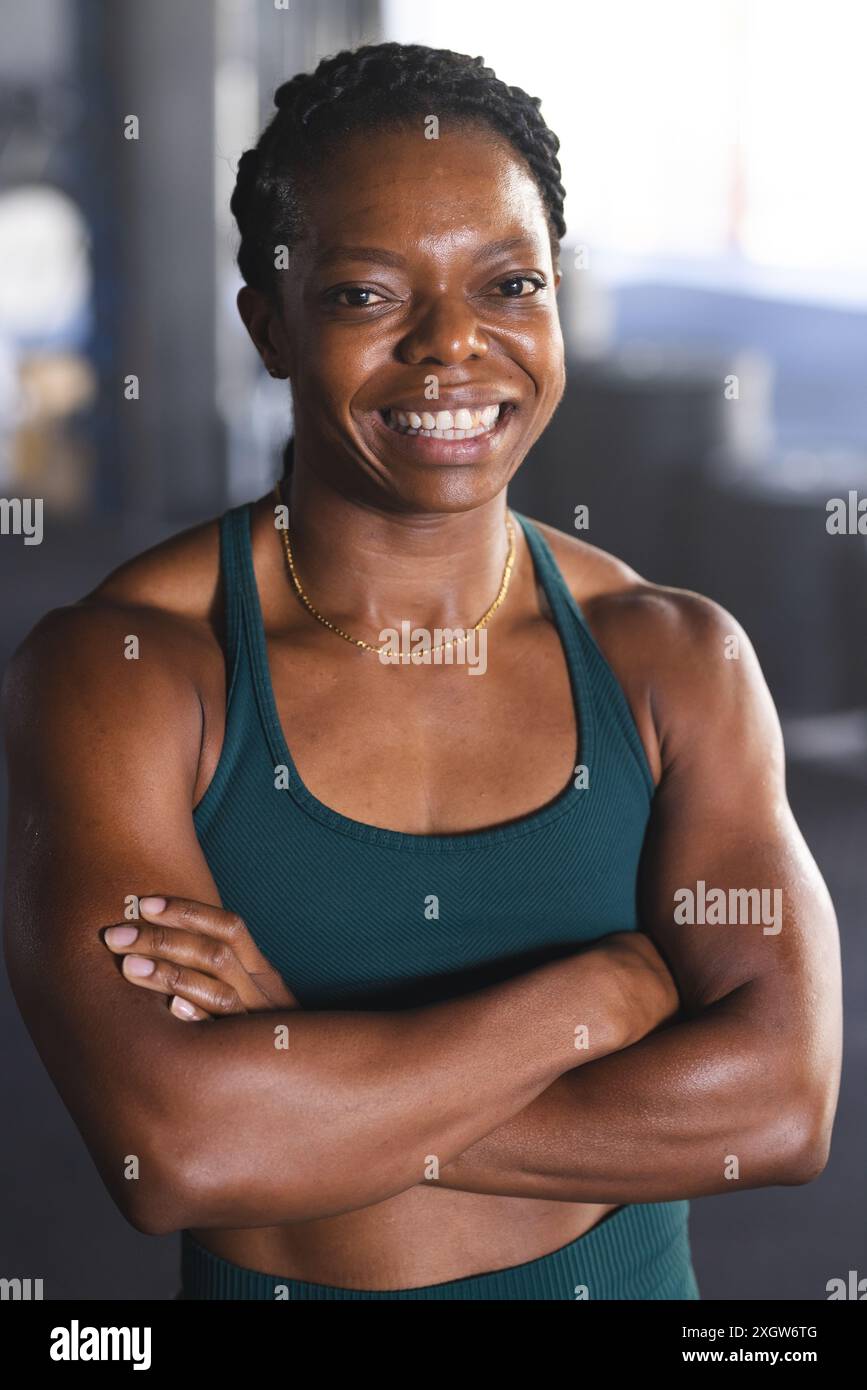 A strong and fit African American woman poses confidently at the gym ...