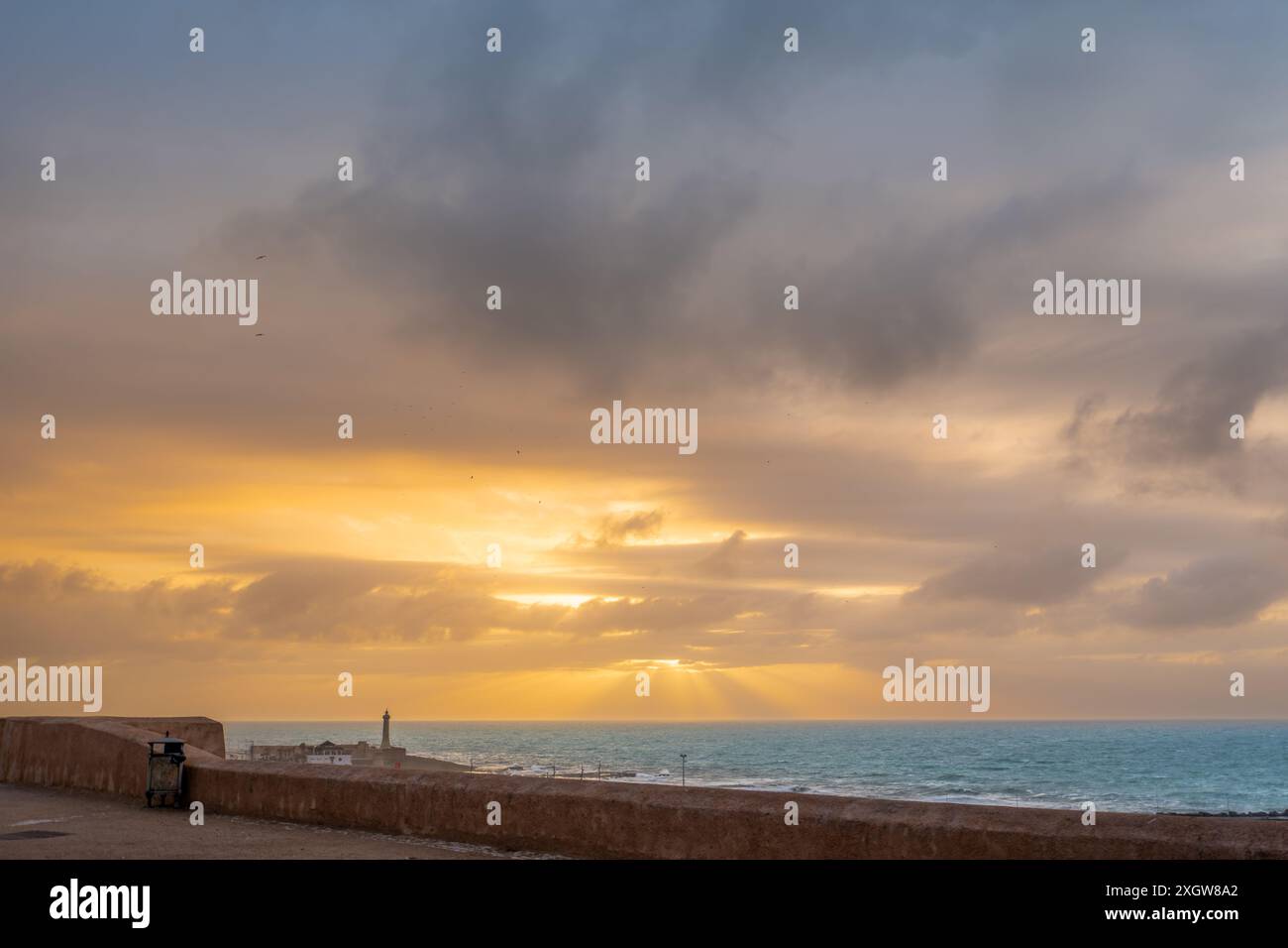 Sunset view over the ocean from Kasbah of Udayas. Sunlight peeks ...