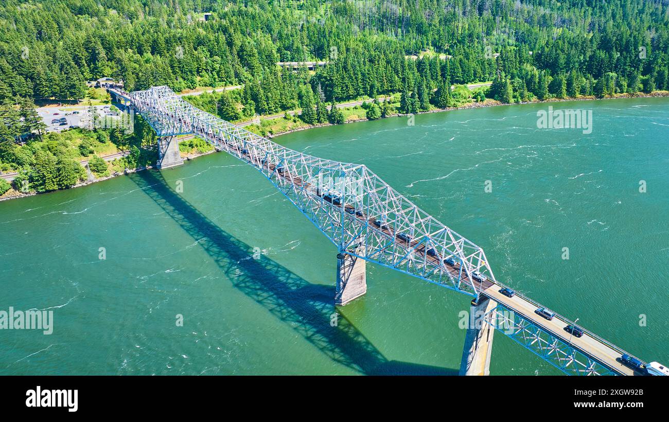 Aerial View of Truss Bridge Over Vibrant River Surrounded by Lush ...