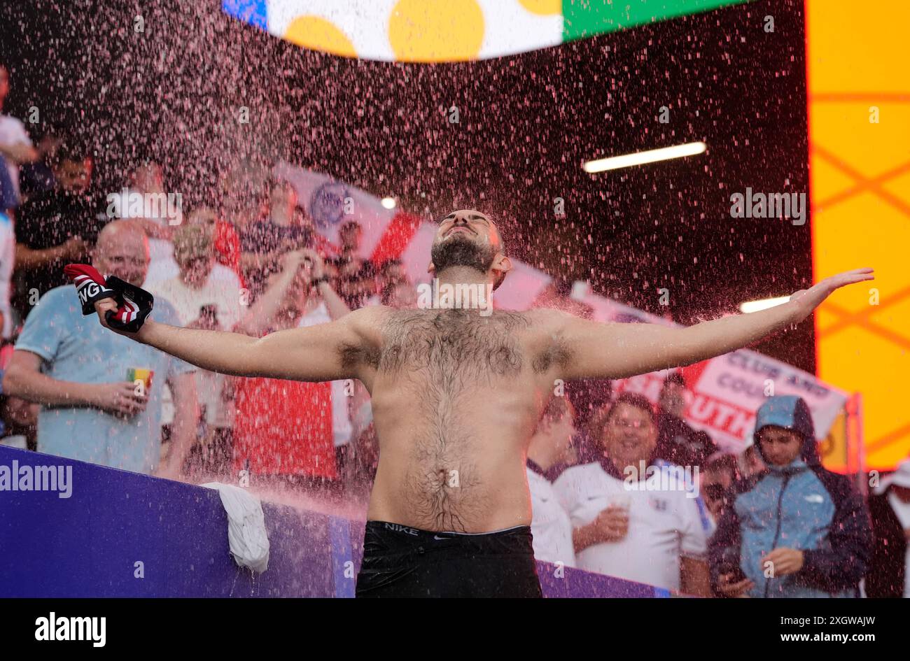 A fan bathes in rainwater falling from the stadium roof before the UEFA ...