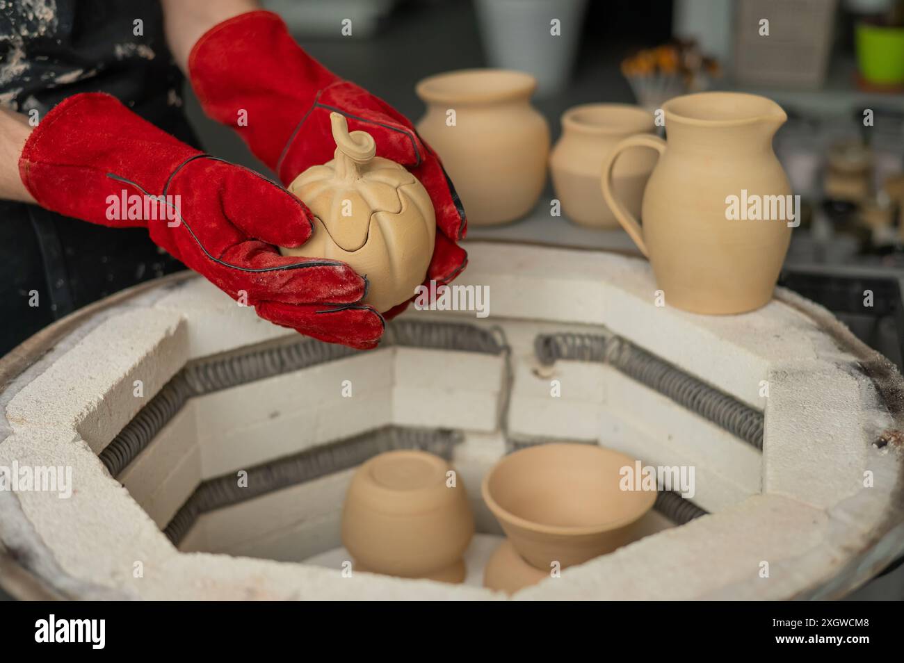 Close-up of a man's hands loading ceramics into a special kiln Stock ...