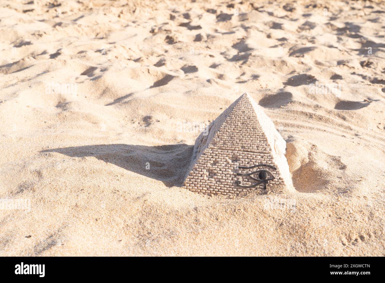 A small stone replica of a pyramid is hidden in the sandy beach ...