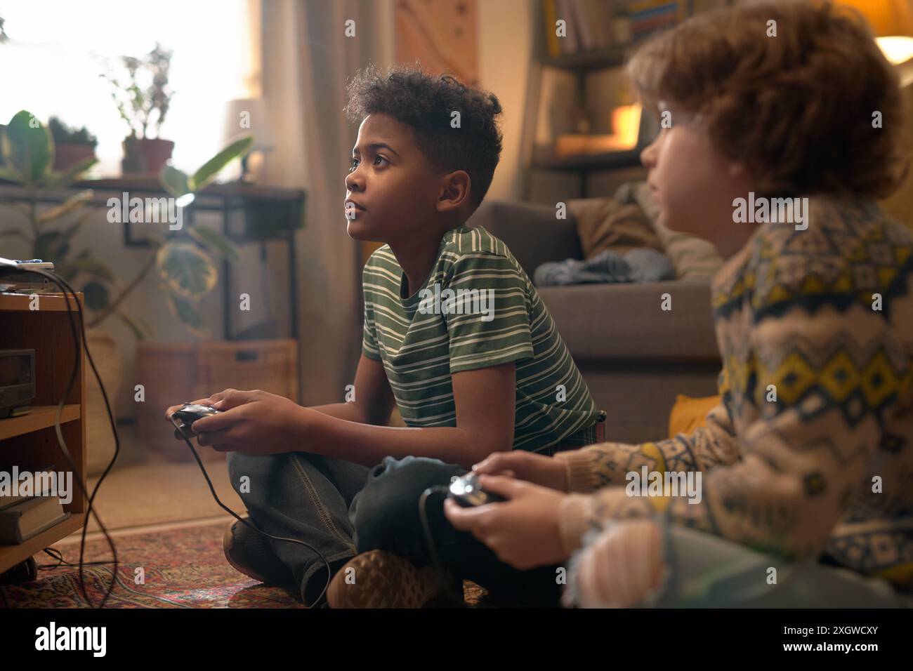 Two schoolboys, one African American and one Caucasian, deeply focused ...