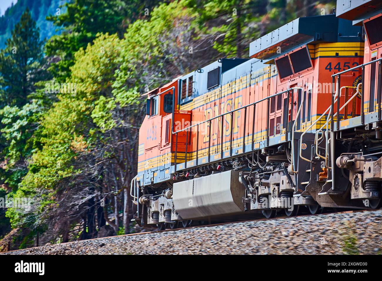 Vibrant Orange Locomotive in Motion Through Lush Forest at Eye Level ...