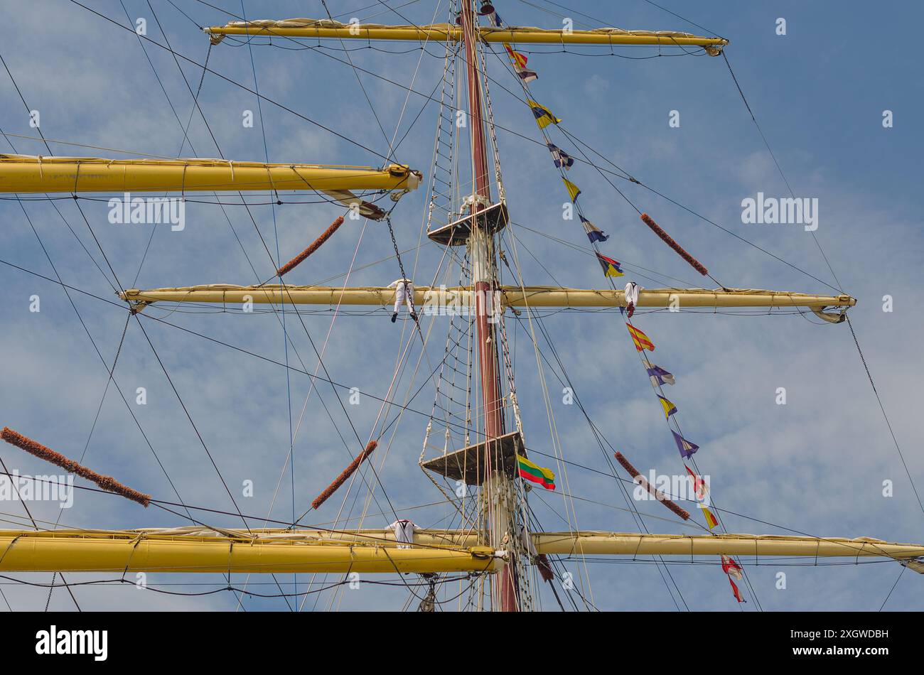 Masts and rigging of a sailing ship against sky with sailors. High ...