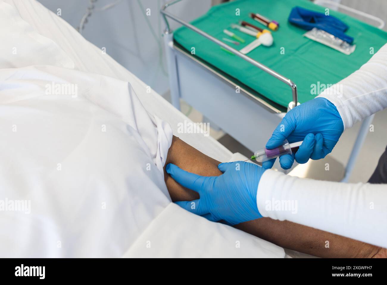 Nurse draws blood from a patient in a medical setting. Sterile ...