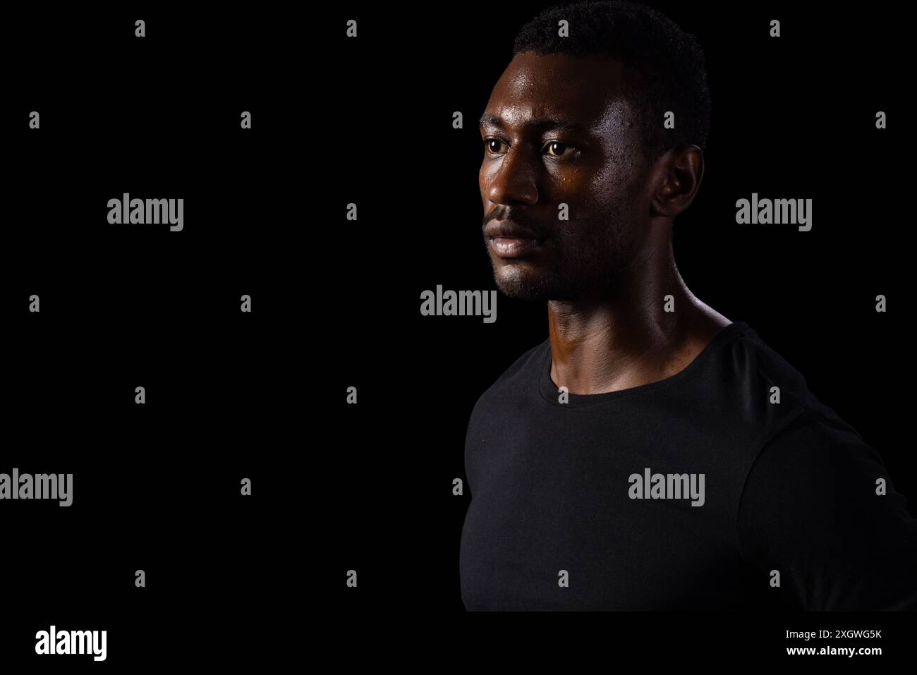 African American man in contemplative pose, with copy space on black ...