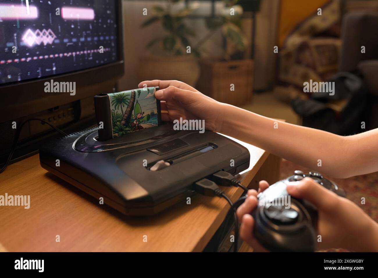 Close up of unrecognizable child inserting cartridge into vintage ...