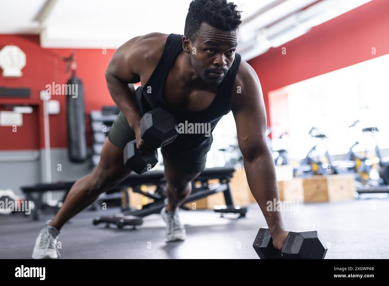 Fit African American man doing dumbbell rows at the gym. His workout ...