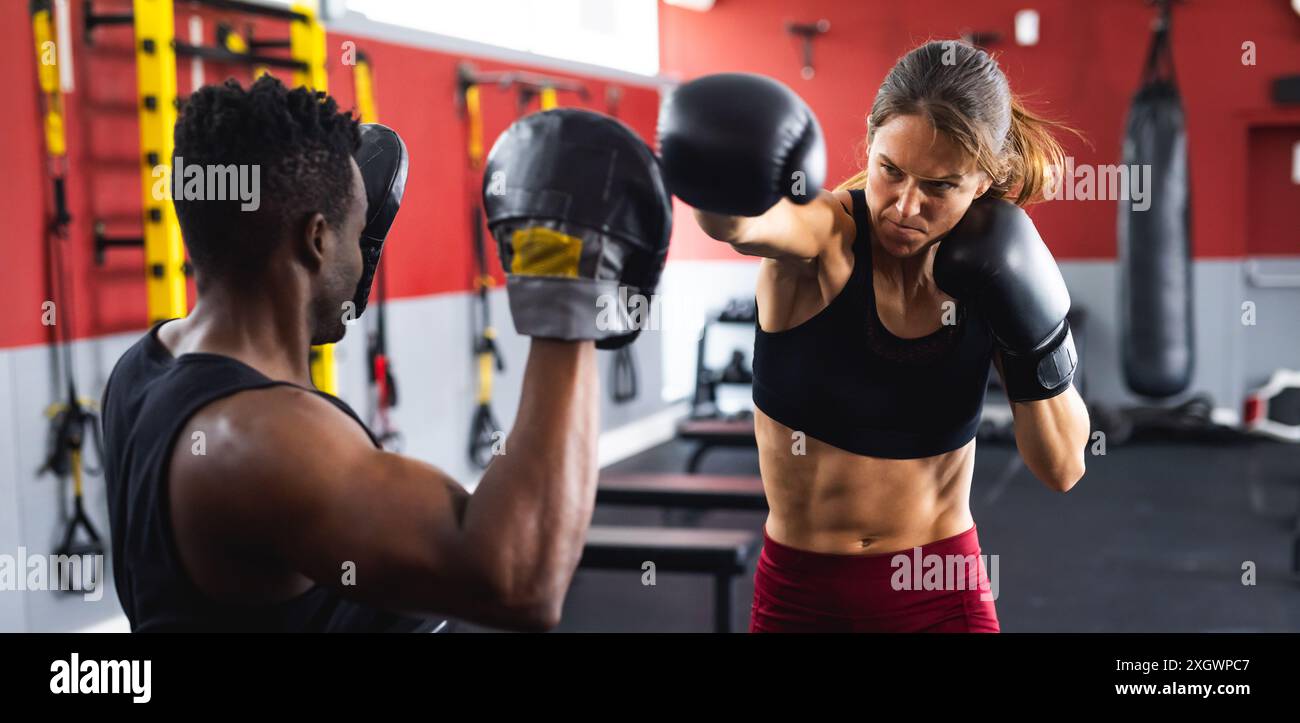 A fit African American man coaches a young fit Caucasian woman in ...