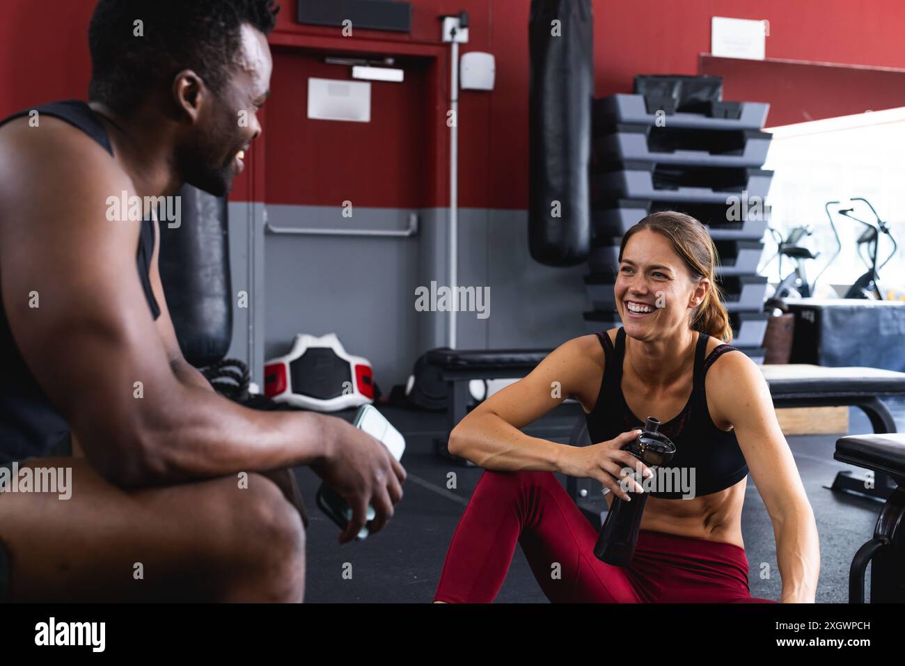 Fit African American man and young Caucasian woman share a laugh at the ...