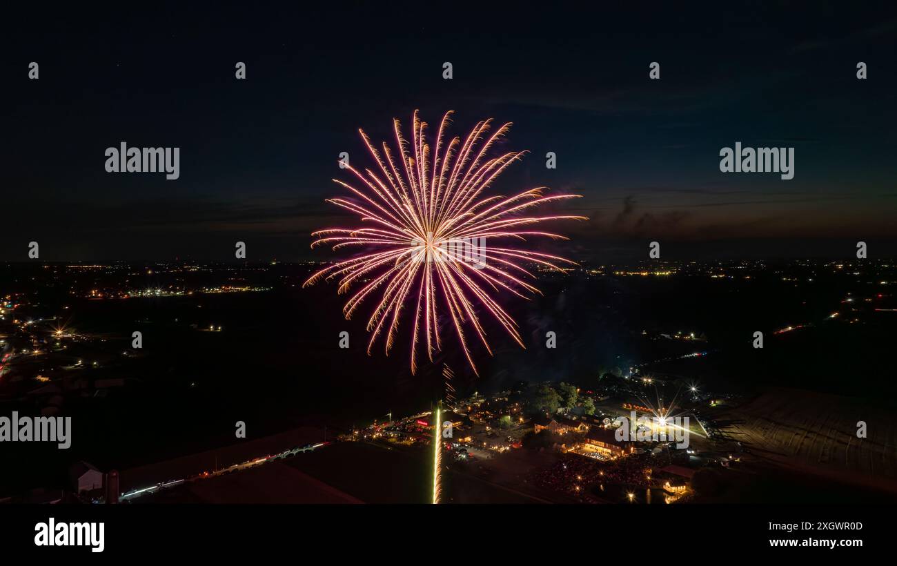 Bright Pink And Gold Fireworks Burst Against The Night Sky Over A Rural ...