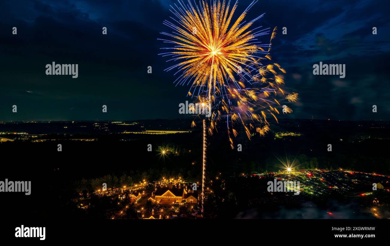 Golden Fireworks Burst Over A Well-Lit Estate, Surrounded By Trees And ...