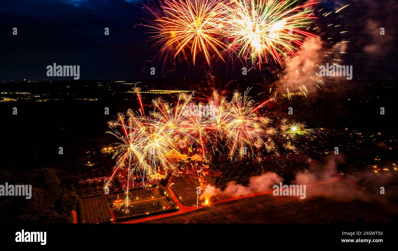 Brilliant Red, Gold, And Green Fireworks Burst Over A Lit Estate ...