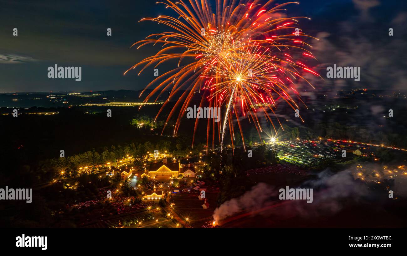 Brilliant Red And Gold Fireworks Burst Over A Well-Lit Estate ...