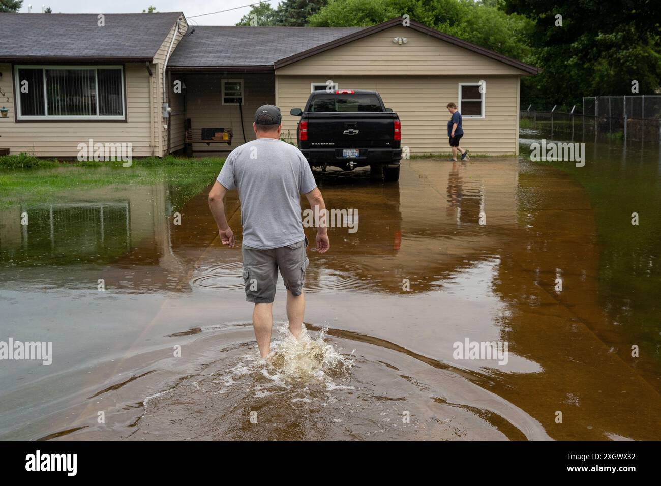 Ken Doyka, and his wife, Ginger Doyka walk through their flooded front ...