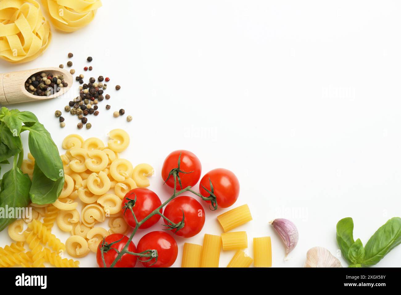 Different types of pasta, spices and products on white background, top ...