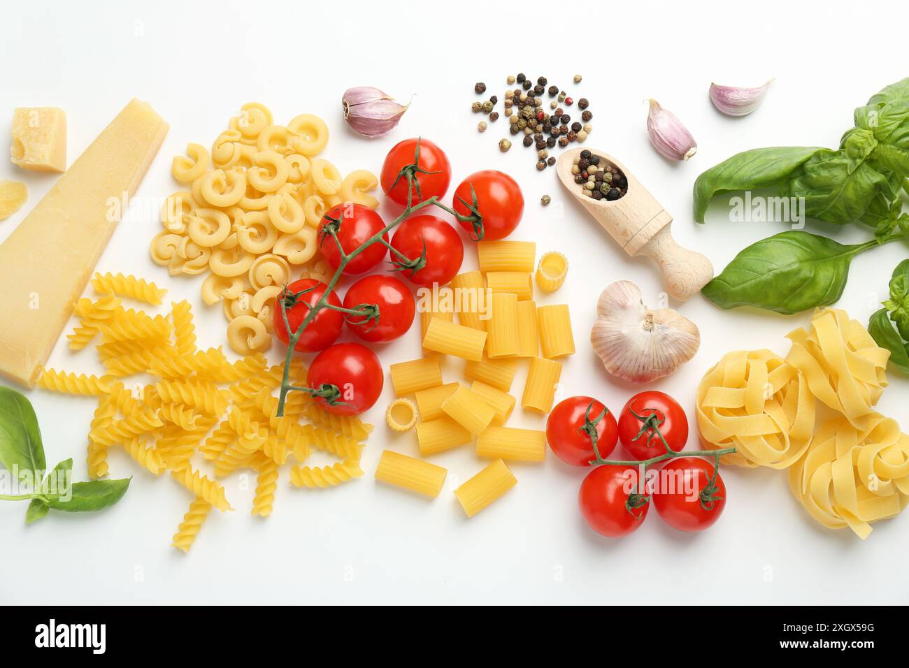 Different types of pasta, spices and products on white background, top ...