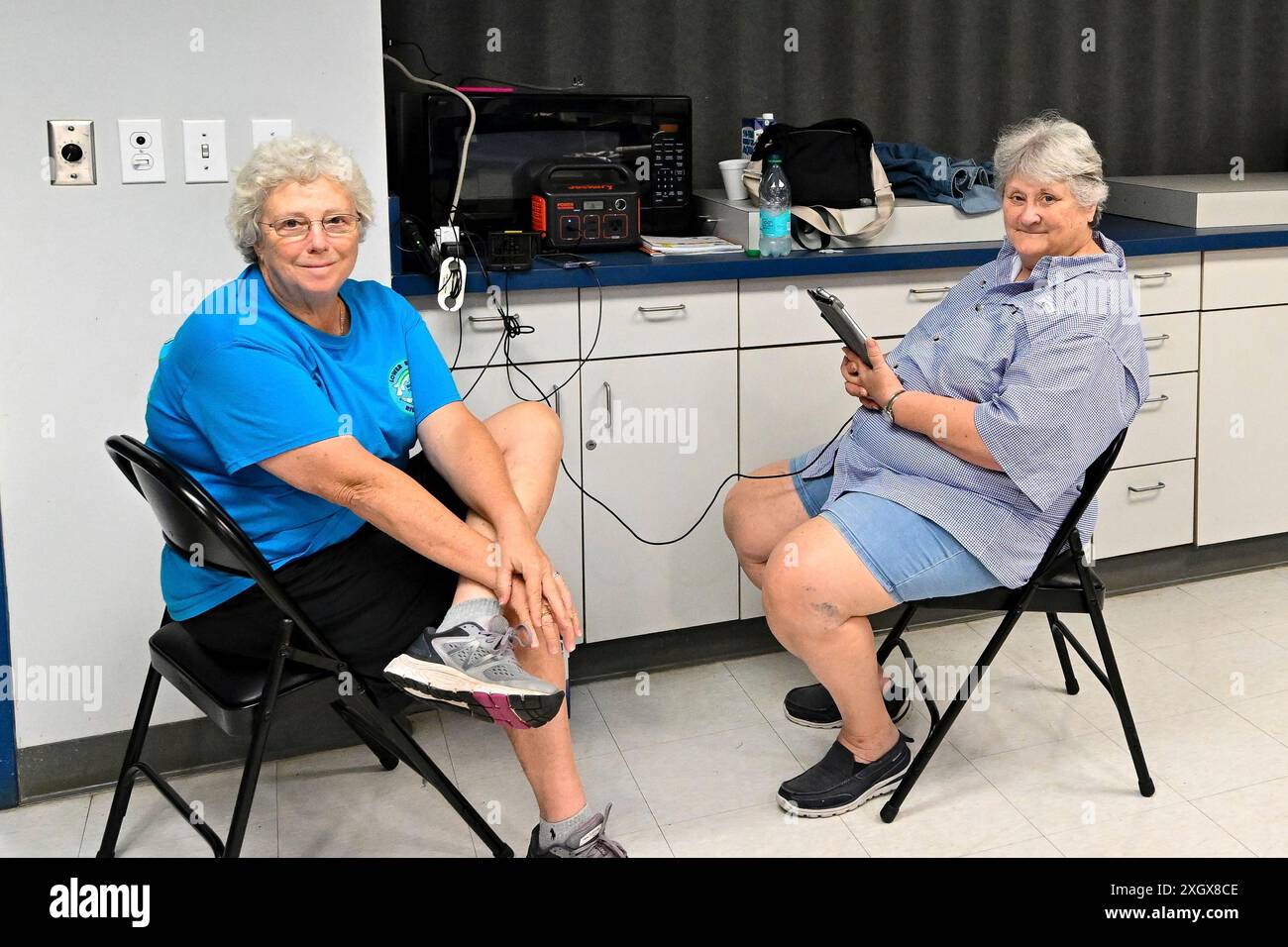 Fran Wilcox, left, and Cynthia Cannon, right, charge their cell phones ...