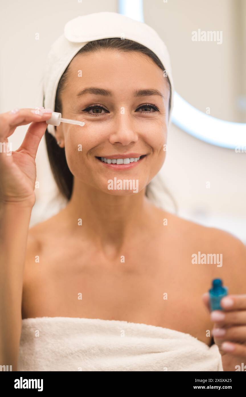 Woman applying anti-age serum on her skin Stock Photo - Alamy