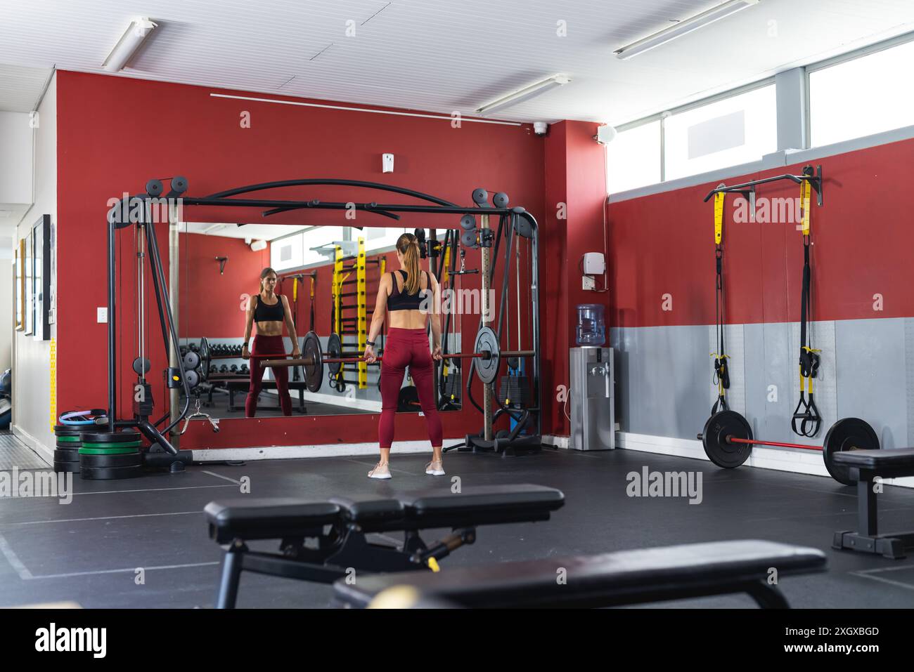 Fit young Caucasian woman exercises at a well-equipped gym. Her workout ...