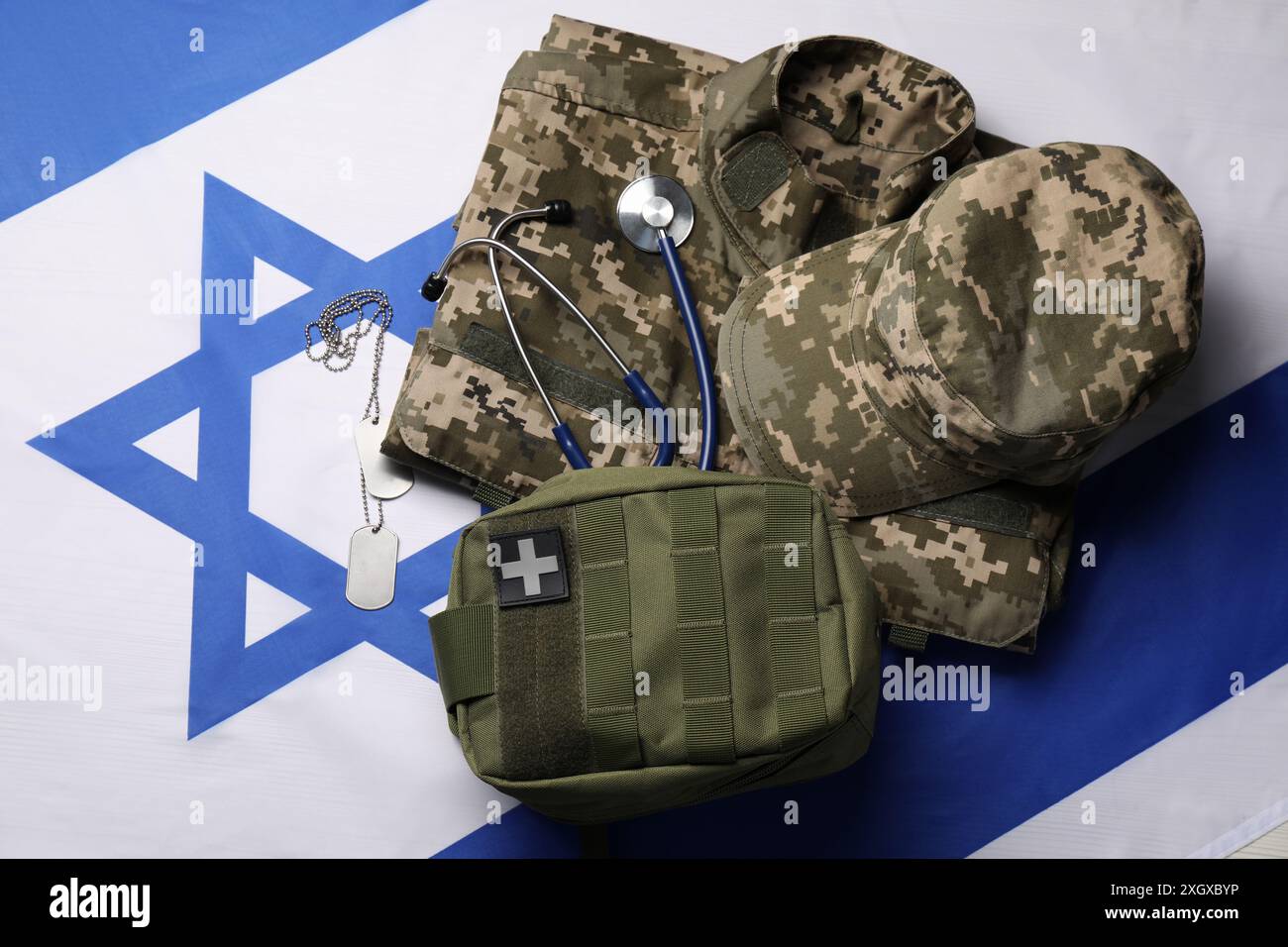 Stethoscope, first aid kit, tags and military uniform on flag of Israel ...