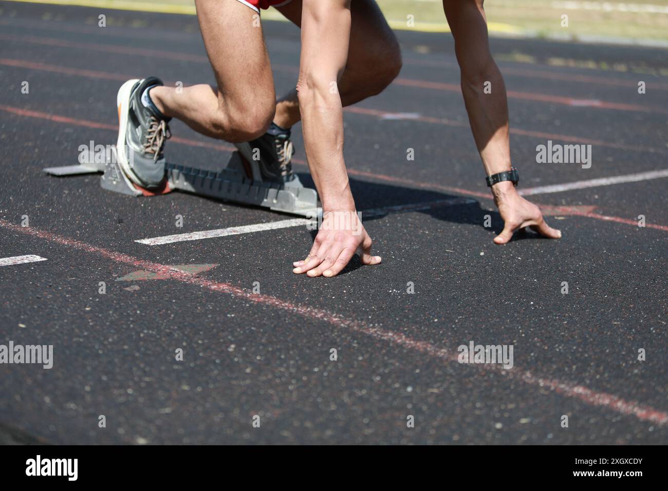 Runner On The Starting Blocks In Position Stock Photo - Alamy