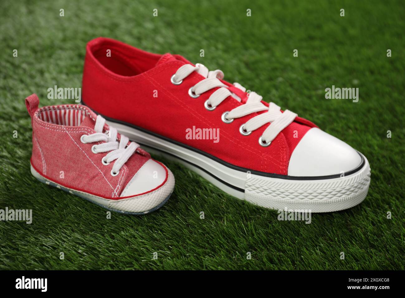 Big and small shoes on green grass Stock Photo - Alamy
