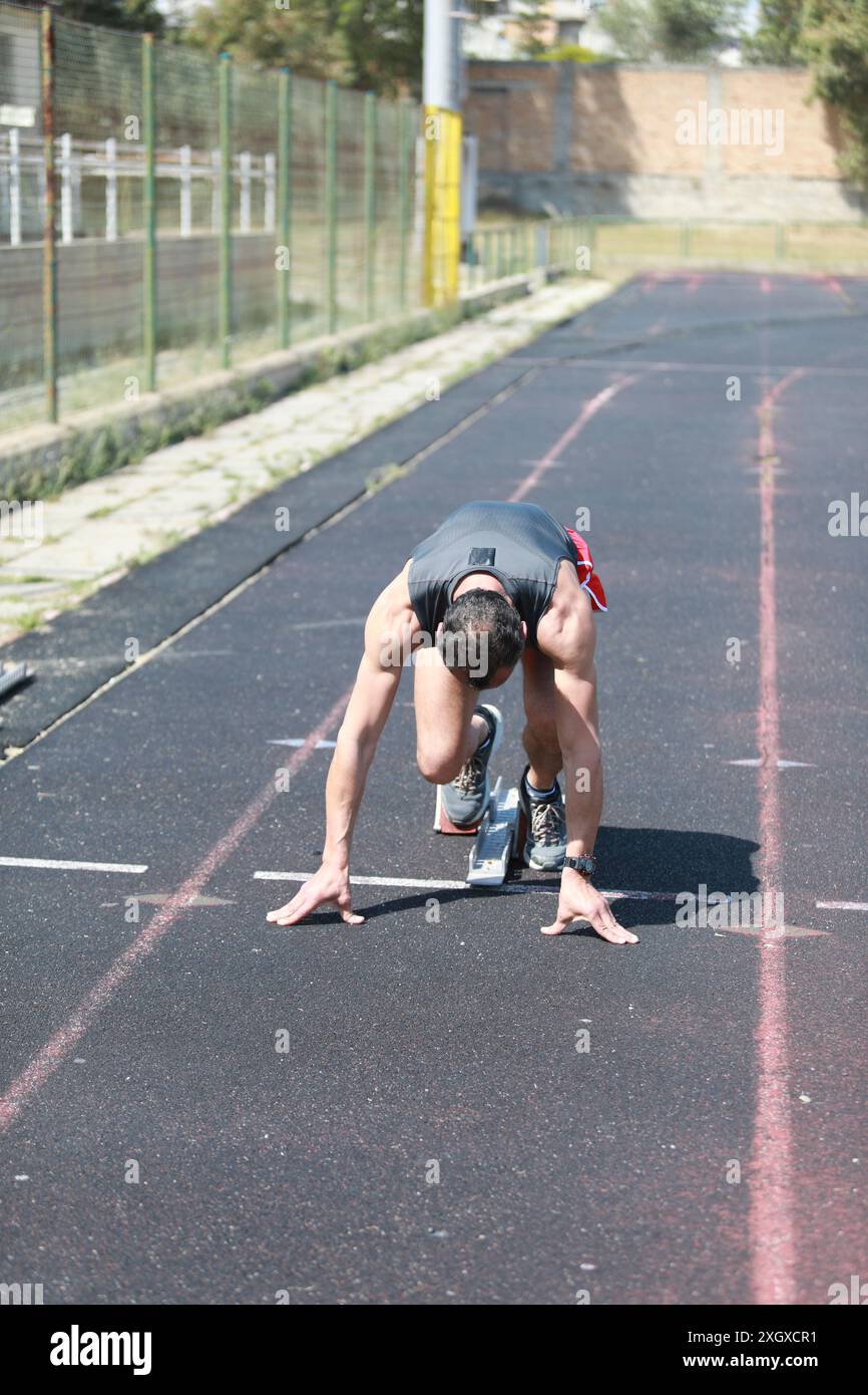 Runner On The Starting Blocks In Position Stock Photo - Alamy