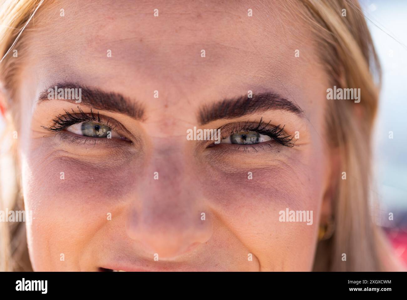 Close-up of a young Caucasian woman's eyes on a road trip. Her gaze is ...