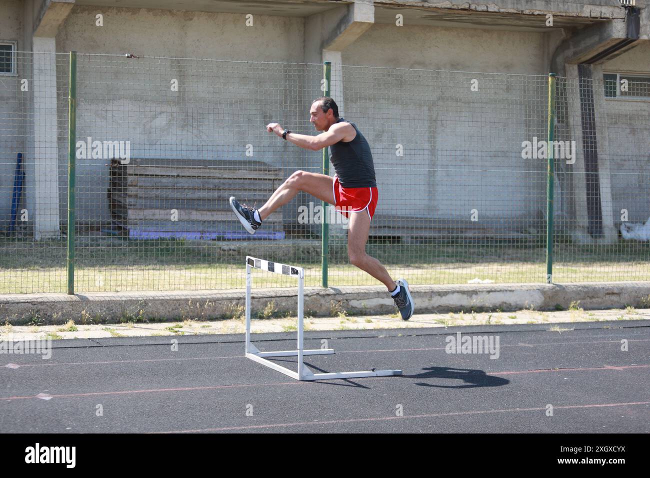 Obstacle Runner Jumping In The Stadium Track Stock Photo - Alamy