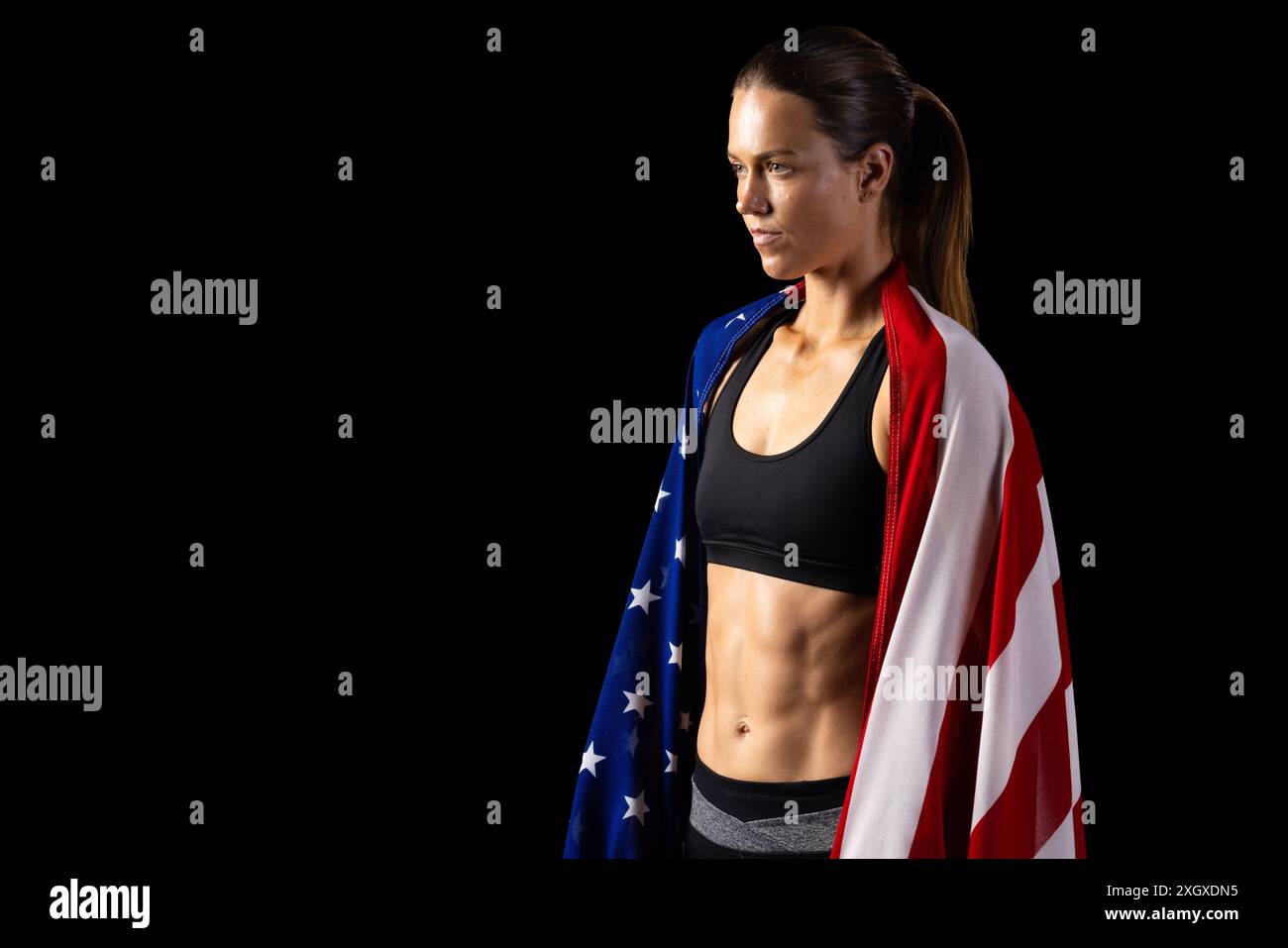 Patriotic young Caucasian female athlete draped in an American flag on ...