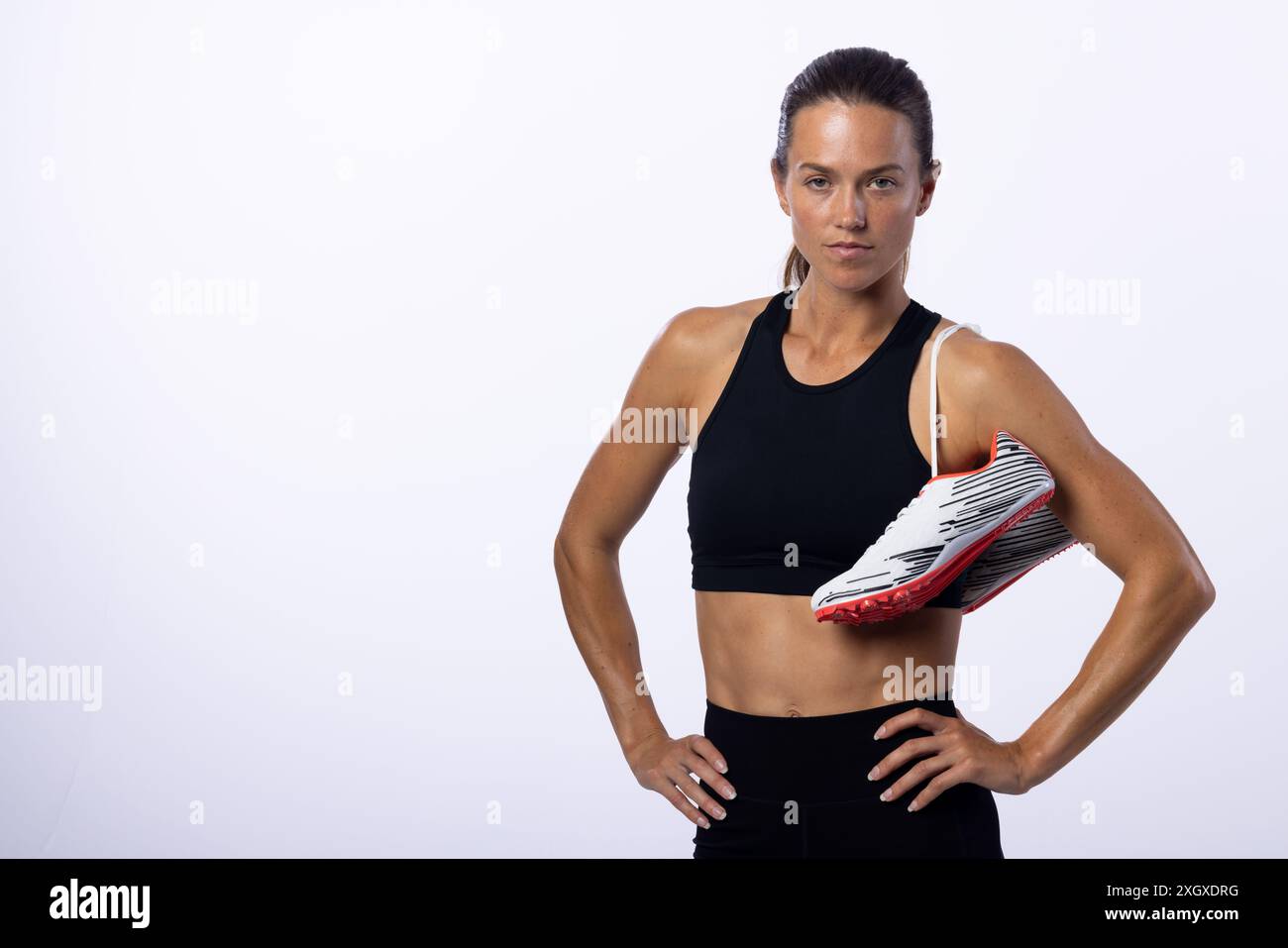 Confident young Caucasian female athlete poses in fitness attire, with ...