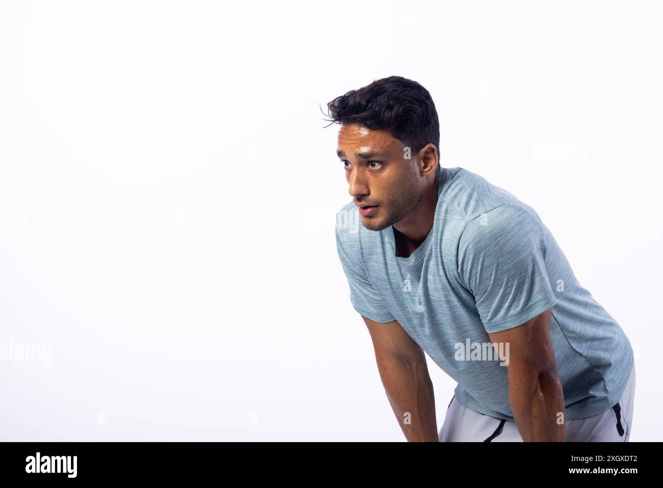 Young biracial man catching his breath after a workout, with copy space ...