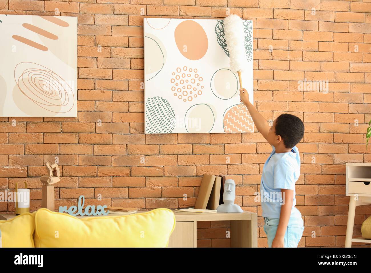 Cute little African-American boy cleaning dust in living room Stock ...