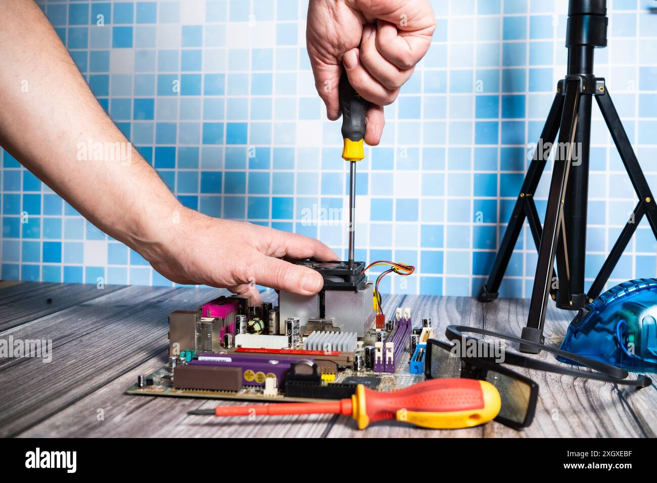 Hands of a Computer technician disassembling a motherboard and recovering components Stock Photo ...