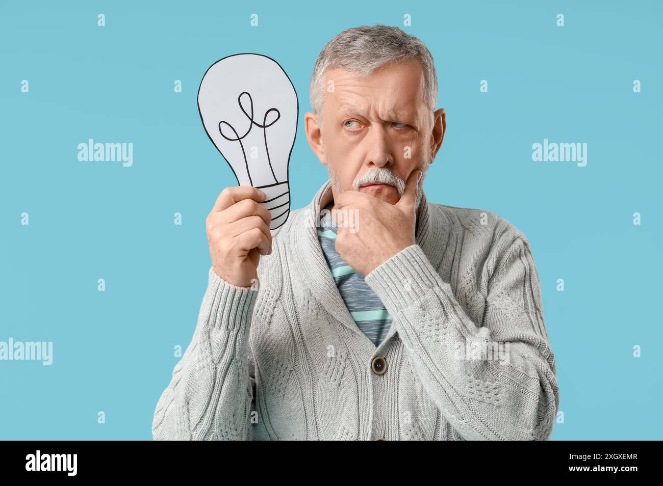 Shocked senior man with paper light on blue background Stock Photo - Alamy