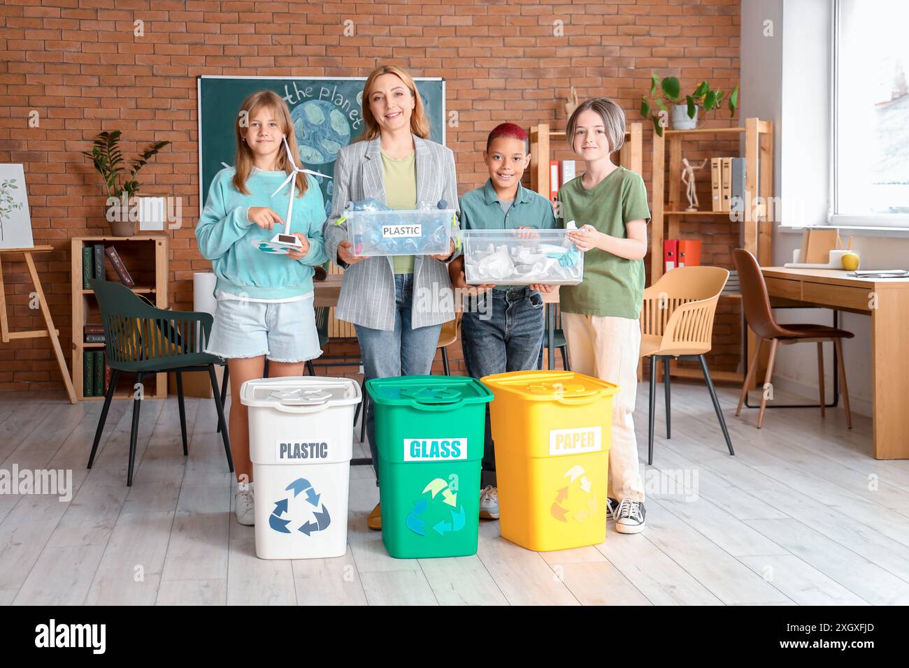 Pupils with teacher sorting garbage in classroom. Ecology concept Stock ...