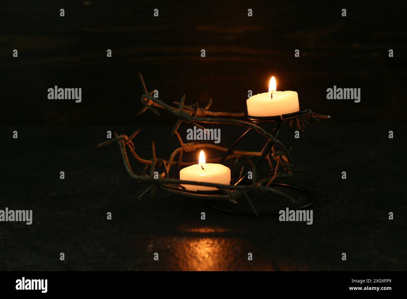 Burning candles with barbed wire on dark background. Day of Remembrance ...