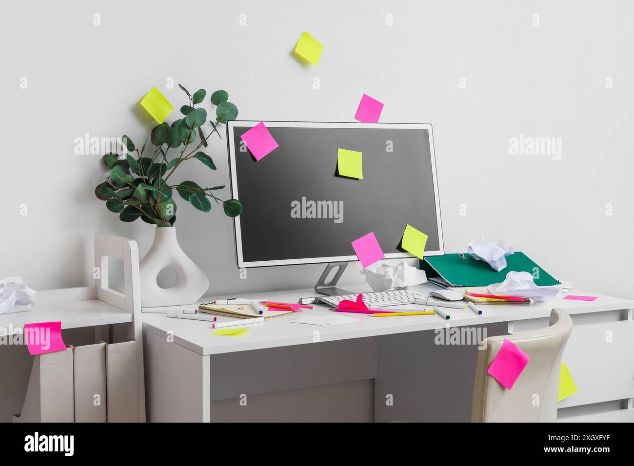 Messy workplace with computer monitor and sticky notes in light office ...