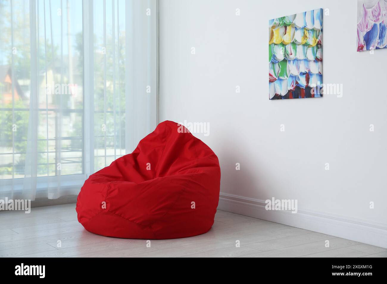 Red bean bag chair near window in room Stock Photo - Alamy