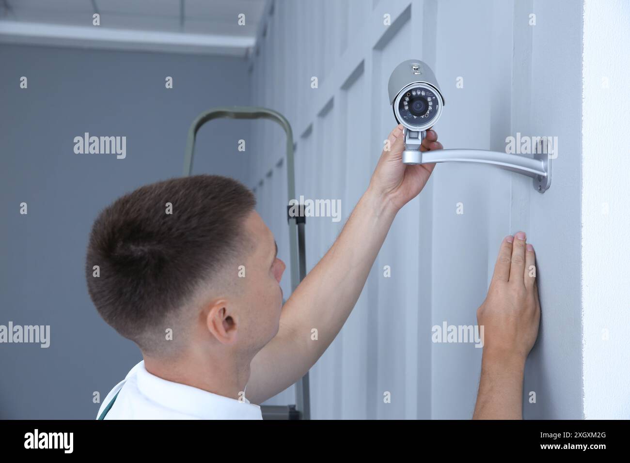 Technician installing CCTV camera on wall indoors Stock Photo - Alamy