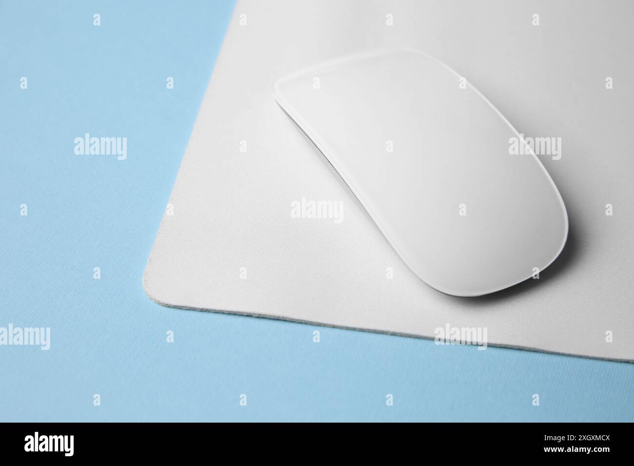 One wireless mouse with mousepad on light blue background Stock Photo ...