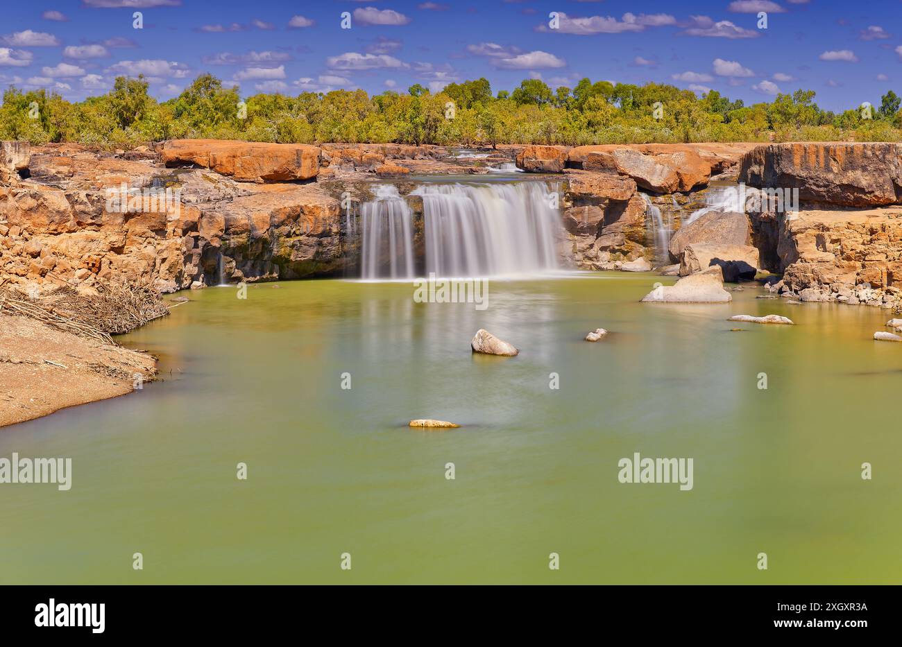 Panorama of Leichhardt Falls plunge waterfall over red rock escarpment ...