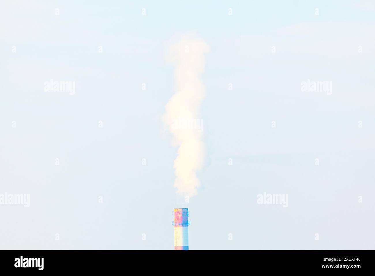 Industrial chimney emitting smoke into the air. Tall smokestack with a ...